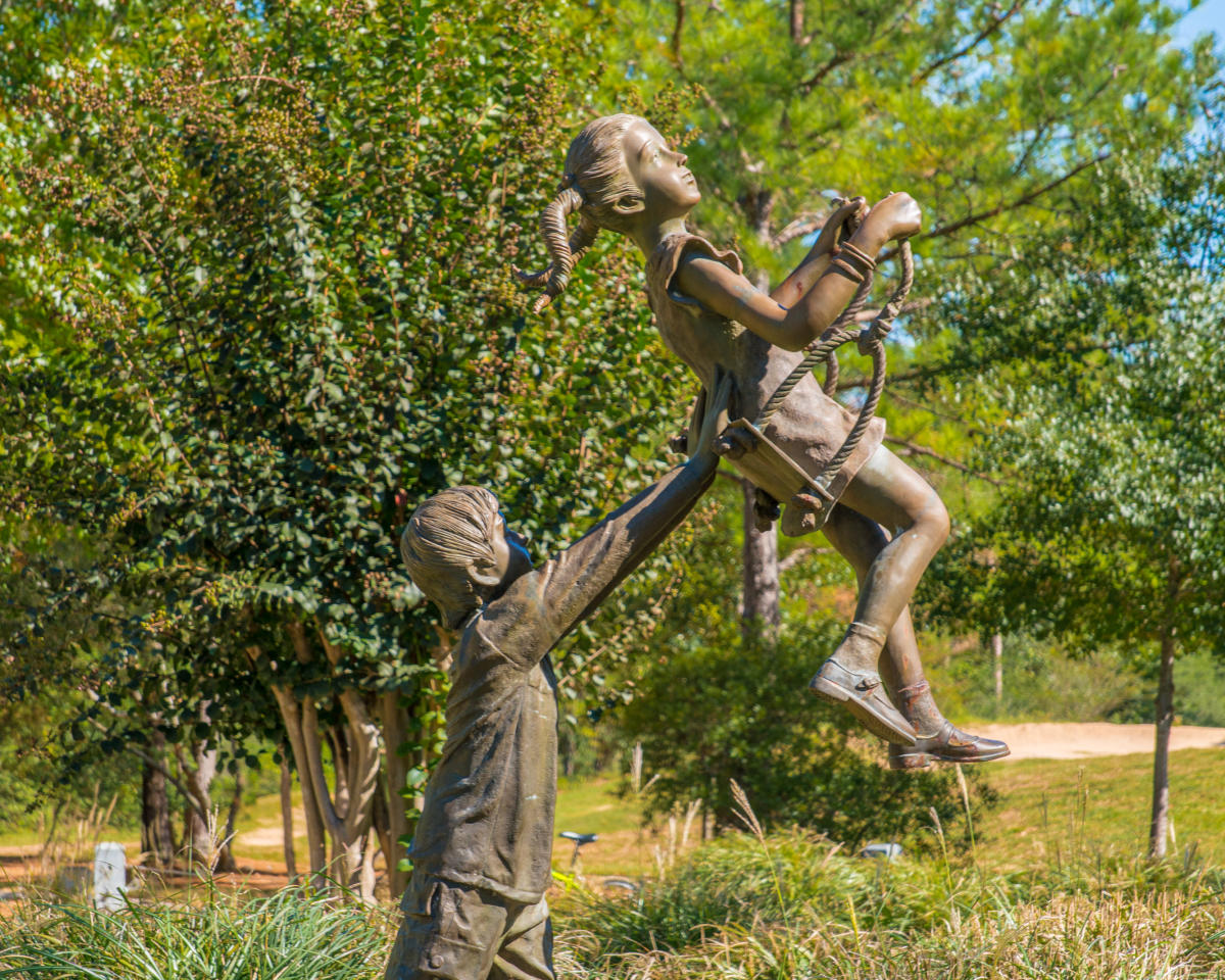Boy Pushing Girl in Swing