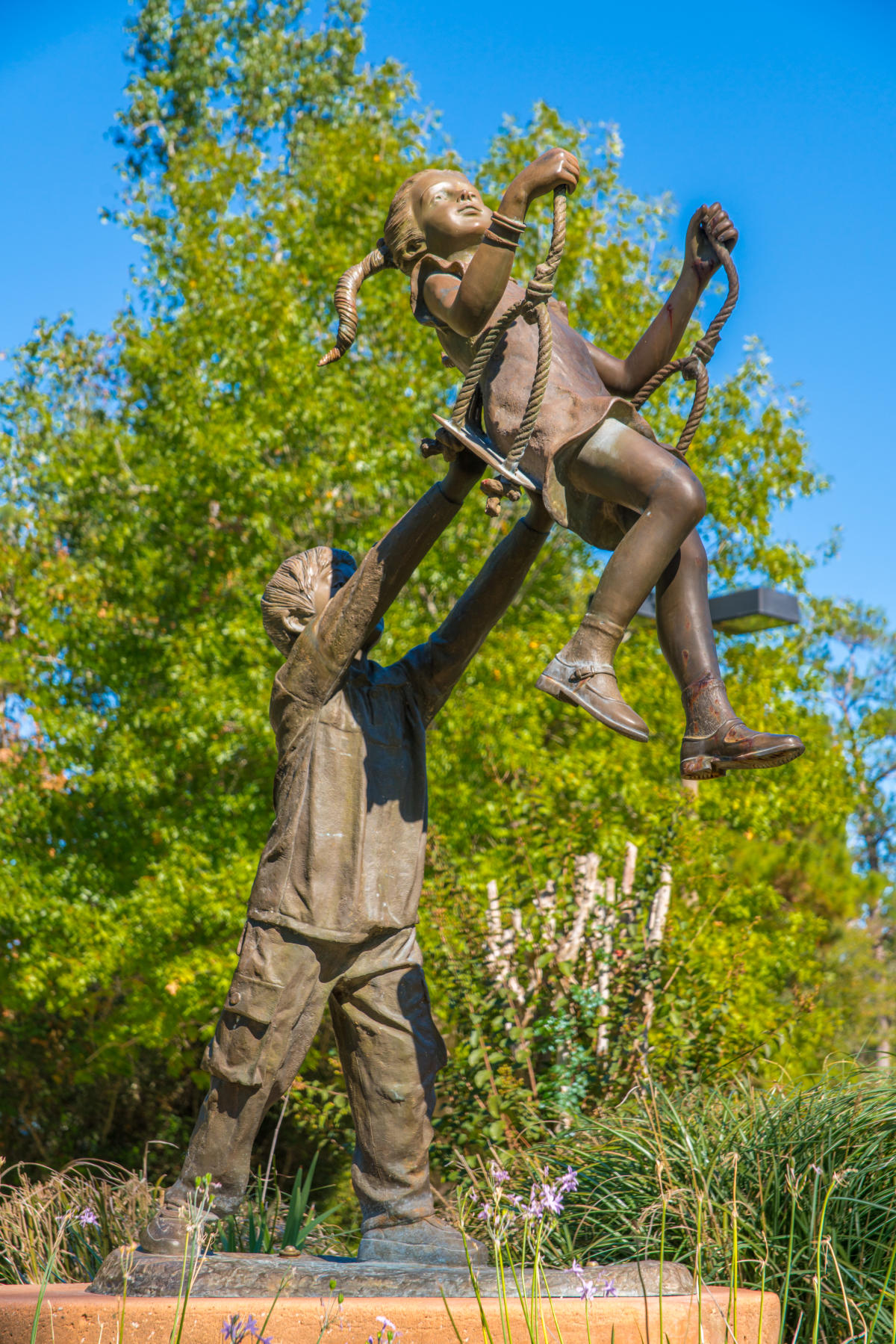 Boy Pushing Girl in Swing